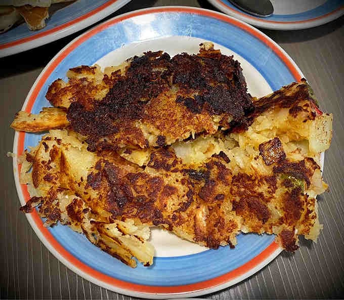 Hash browns achieving that golden-brown crispy exterior that makes you question why potatoes come any other way.