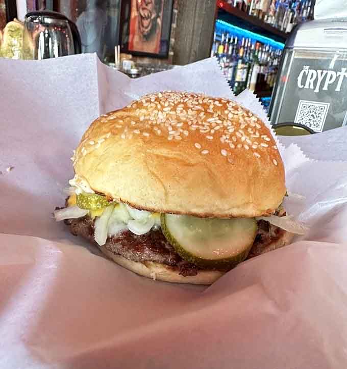 The Crypt Burger sits pretty on a sesame bun, loaded with pickles and enough cheese to haunt you forever.