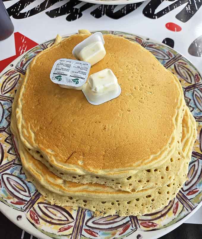 These golden pancakes at The Gem Diner stack up like edible architecture with butter on top.