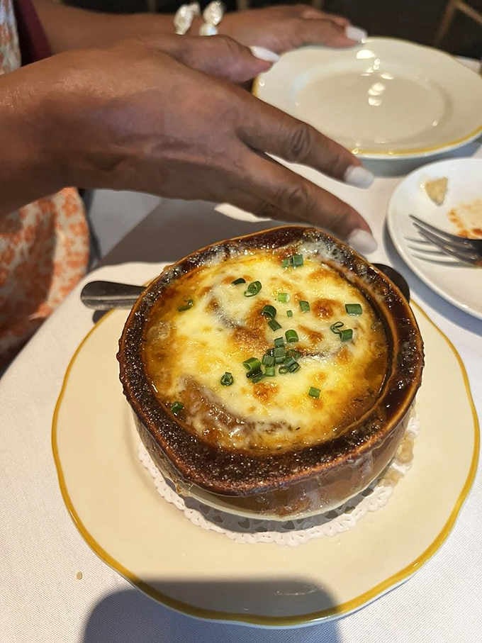 French onion soup bubbling under a cheese blanket so golden it deserves its own declaration of independence.