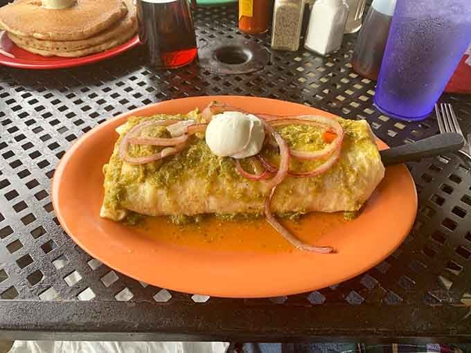 That burrito is smothered in chile verde like it's auditioning for a delicious green blanket commercial.