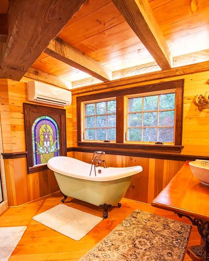 A clawfoot tub with stained glass in a treehouse bathroom &ndash; Swiss Family Robinson never had it this good.