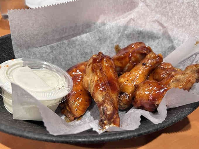 These wings arrive sauced and ready, with bleu cheese dressing standing by for cooling relief.