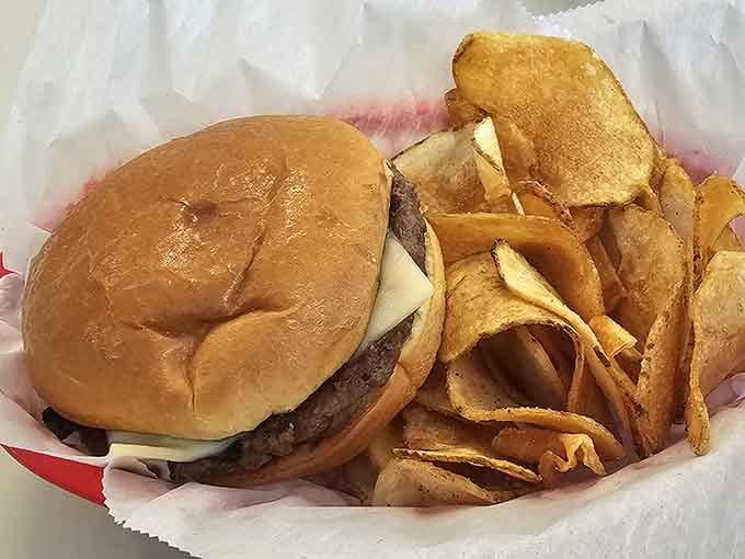 A perfectly grilled burger with crispy chips shows that classic combinations never go out of style.