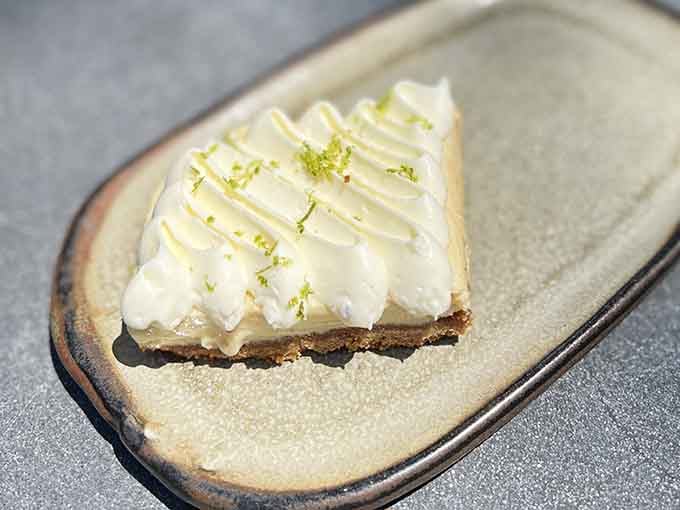 Key lime pie bar with that perfect swirl of cream, because sometimes your book needs a sweet companion.