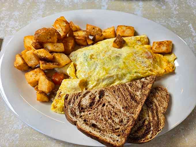 That fluffy omelet with golden hash browns and marbled rye toast is basically a hug on a plate.