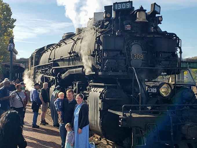 Passengers gather around the steam locomotive, proving that massive machines still inspire wonder at any age.