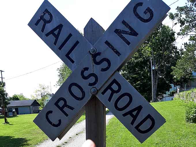 That weathered crossing sign has seen more action than most Netflix series, and it's still standing strong.