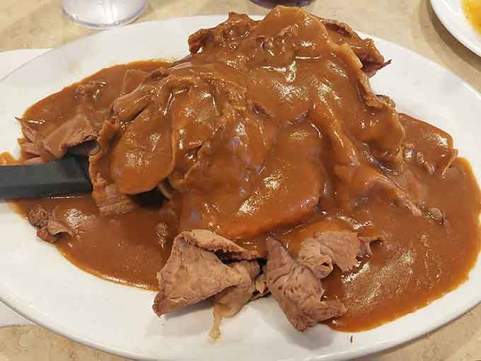Roast beef swimming in gravy like it's found its natural habitat and never wants to leave.