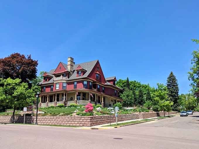 This grand Victorian mansion painted in deep burgundy commands attention like a dowager empress surveying her domain.