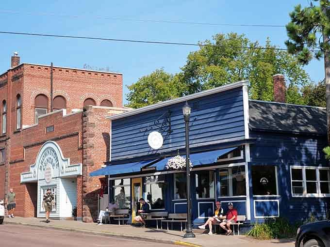 The blue-painted storefront pops against red brick neighbors, creating a vibrant downtown scene full of character.
