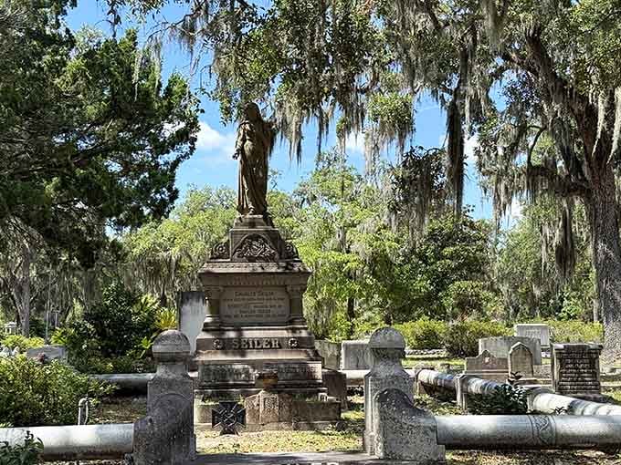 Majestic monuments rise beneath cascading Spanish moss in this outdoor gallery where art meets eternal rest beautifully.