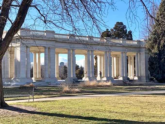 Classical white columns create dramatic shadows across the pavilion, standing proud against Denver's brilliant blue sky.