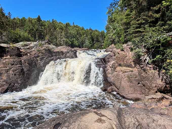 Raw power meets ancient rock as the waterfall crashes down, nature's force on full, thunderous display here.