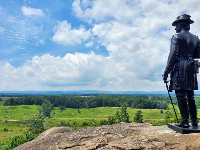 Standing sentinel over hallowed ground, this bronze soldier gazes across fields where history changed America's course forever in 1863.