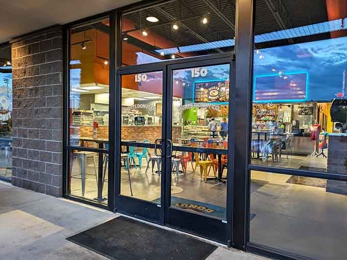 Floor-to-ceiling windows reveal a bright, inviting interior that looks like a donut lover's version of Willy Wonka's factory.