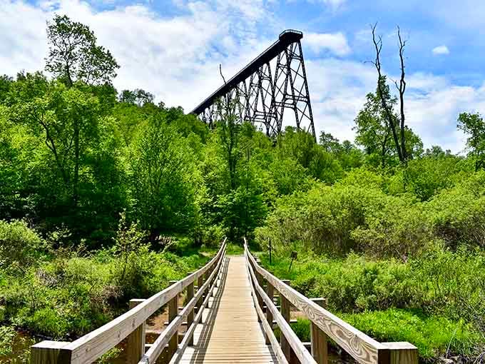 The wooden walkway leads your eye straight to that dramatic iron skeleton rising above the lush green valley.