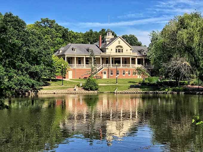 The pavilion's warm brick and elegant columns reflect perfectly in still lagoon waters, doubling the beauty like nature's own mirror trick.