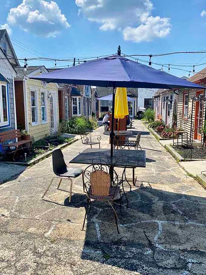 This sunny courtyard setup shows that outdoor dining and community gathering spaces make life richer without making you poorer.