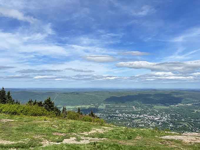 From this summit, the world spreads below in green valleys and distant peaks that stretch beyond tomorrow's horizon.