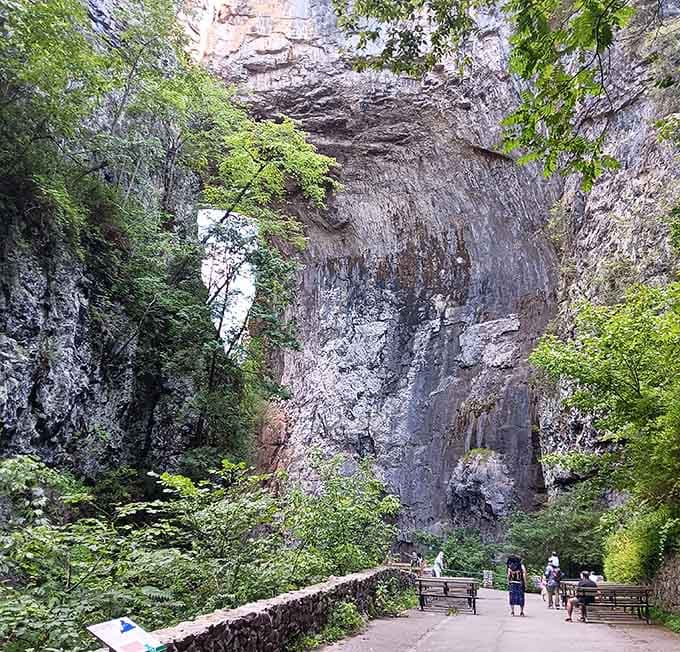 Towering limestone walls create a natural cathedral where ancient stone meets modern walking paths below.