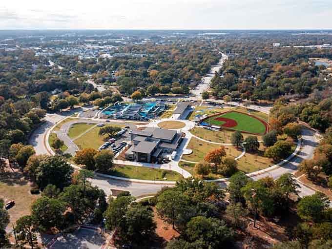 Baseball diamonds and bright blue water slides create a family paradise where kids' laughter echoes across autumn-touched trees.