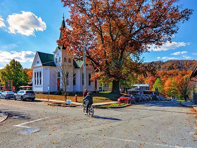 A white church steeple rises against autumn's blazing colors, framing small-town America at its most picture-perfect moment.