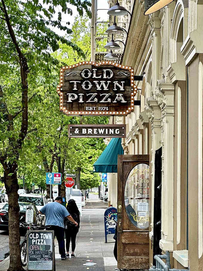 That vintage marquee sign practically glows with old-school charm, promising pizza and spirits in a building that remembers Portland's wildest days.