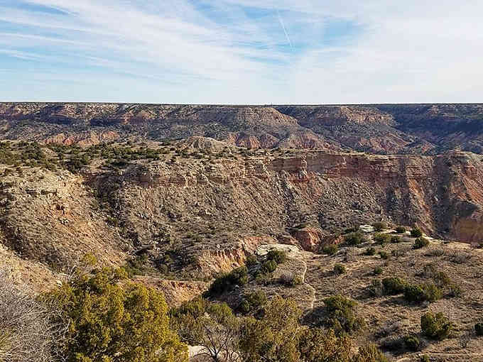 Layers of red, orange, and purple rock tell millions of years of geological stories in this dramatic canyon landscape.