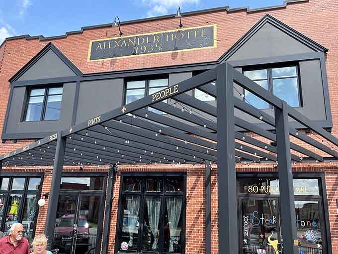 Historic brick meets modern design elements under the Alexander Hotel sign, creating an inviting small-town atmosphere.