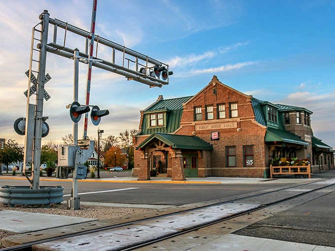 Railroad crossing signals frame this charming depot building, where trains still rumble through like they have for generations.