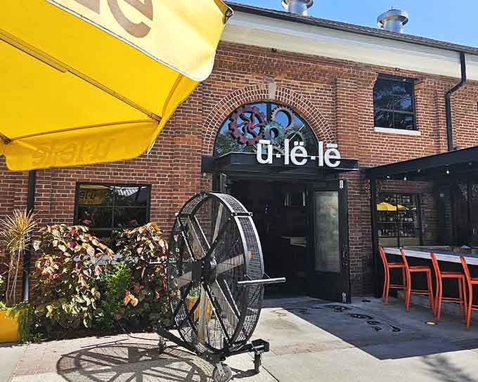 Those cheerful yellow umbrellas pop against red brick like sunshine breaking through on a perfect dining day.