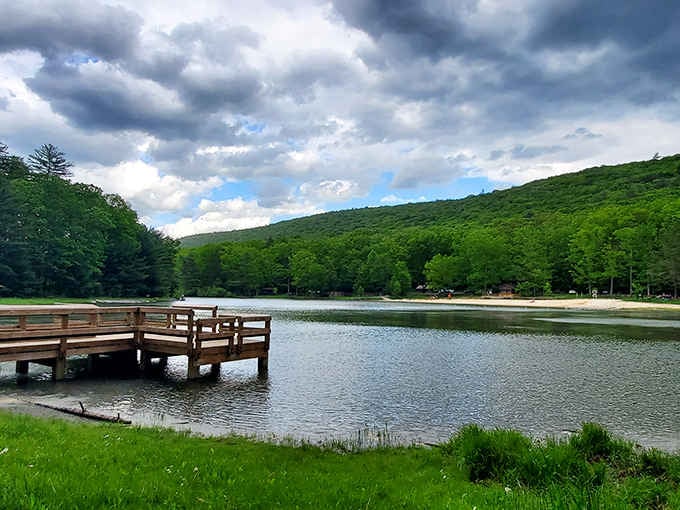 Storm clouds gather over mountain-ringed waters where that wooden dock beckons you to sit and contemplate everything.