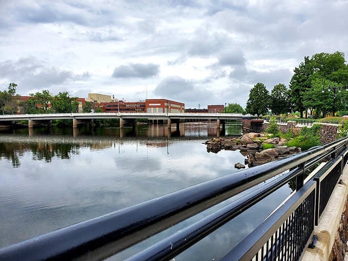 The river reflects both sky and town in this tranquil waterfront scene where nature meets neighborhood.