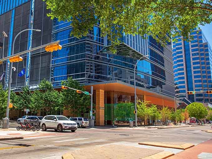 Modern glass architecture catches the sunlight beautifully, creating a downtown corner where contemporary design meets traditional Texas hospitality and warmth.