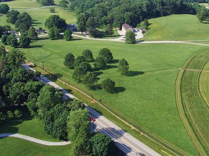 Rolling farmland stretches endlessly green, dotted with trees like nature's own perfectly planned landscape design.