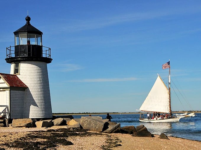 A classic sailboat glides past as if posing for a postcard, making this scene almost too perfect to believe.