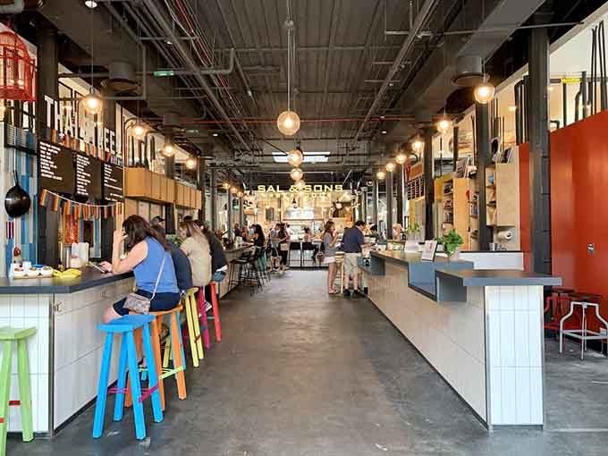 Inside, colorful stools and industrial charm blend perfectly, creating a vibrant gathering space for neighbors and visitors.