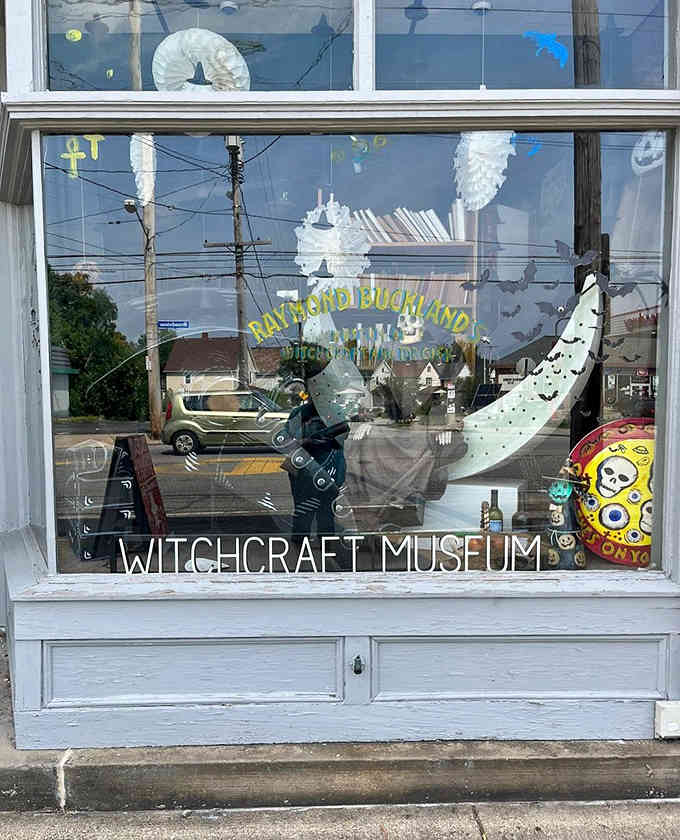 Whimsical window art featuring spell books and mystical creatures hints at the fascinating collection of witchcraft history housed inside.