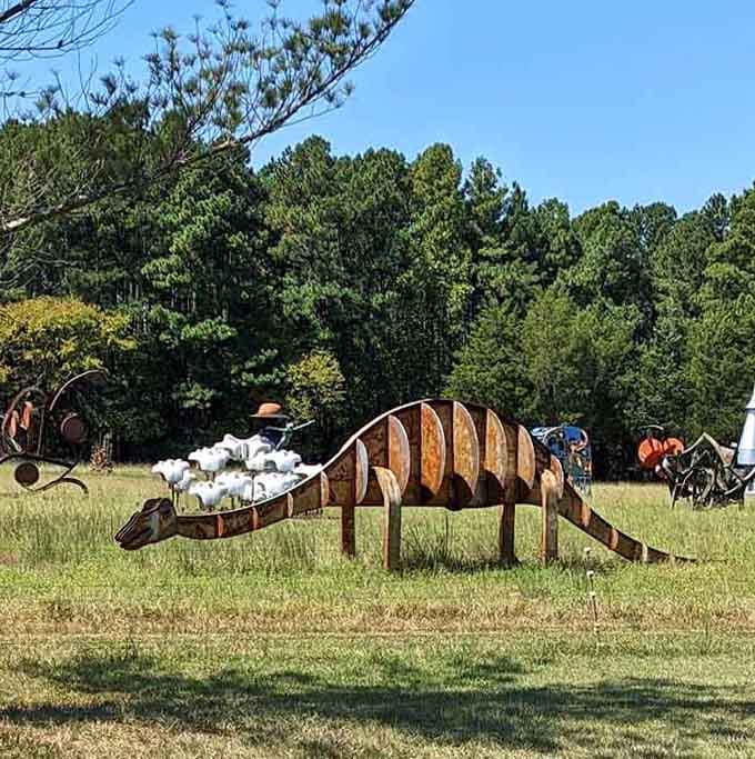 This whimsical metal dinosaur grazes peacefully among scattered sculptures, creating an outdoor gallery of pure imagination.