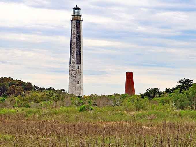The taller lighthouse and its shorter companion stand together across the marsh, a testament to maritime history's evolution.