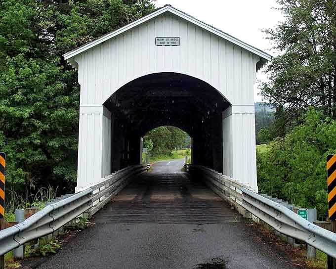 Step inside this historic covered bridge where wooden planks and shadowy beams whisper stories from another era.