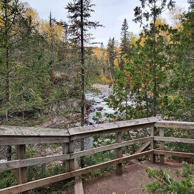 Autumn colors frame the rushing river along wooden railings, where the trail rewards hikers with North Shore beauty.