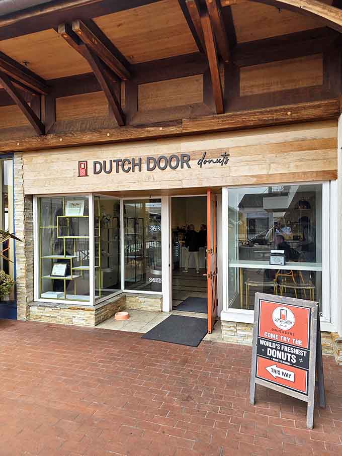 Rustic wood beams overhead create a charming atmosphere where fresh donuts cook right before your delighted eyes.