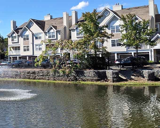 Waterfront living meets suburban comfort where townhomes reflect peacefully in the calm waters below.