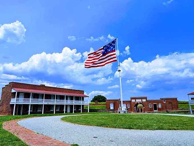 Old Glory waves proudly above historic fortifications under brilliant blue skies, reminding us why freedom is worth defending and celebrating.