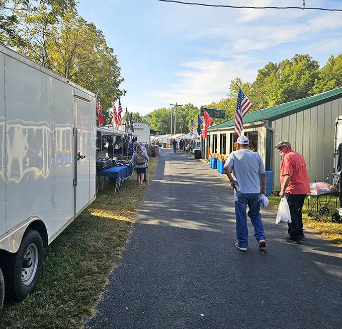 Flags wave proudly as shoppers stroll past vendor booths, creating a festive atmosphere that beats any shopping mall.