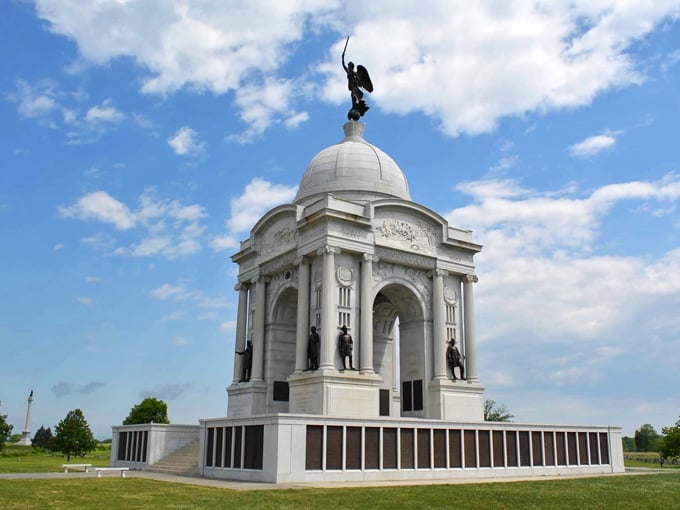 The Pennsylvania State Memorial rises majestically against summer clouds, honoring those who fought on these rolling green hills long ago.
