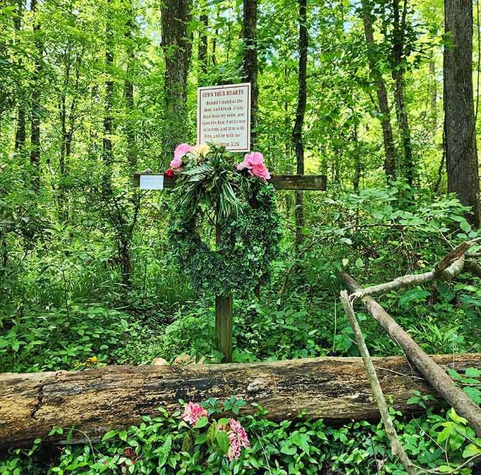 Pink flowers frame this woodland shrine where hope springs eternal among the towering trees.