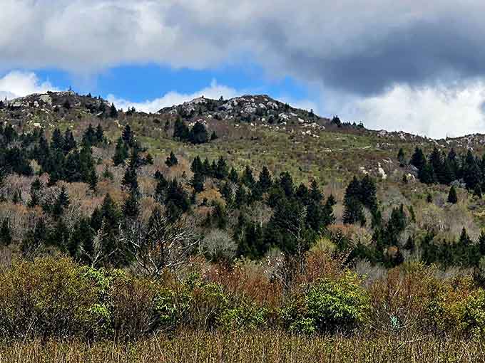 Dramatic storm clouds gather over rocky peaks where ancient stones crown the highlands like nature's own castle battlements.
